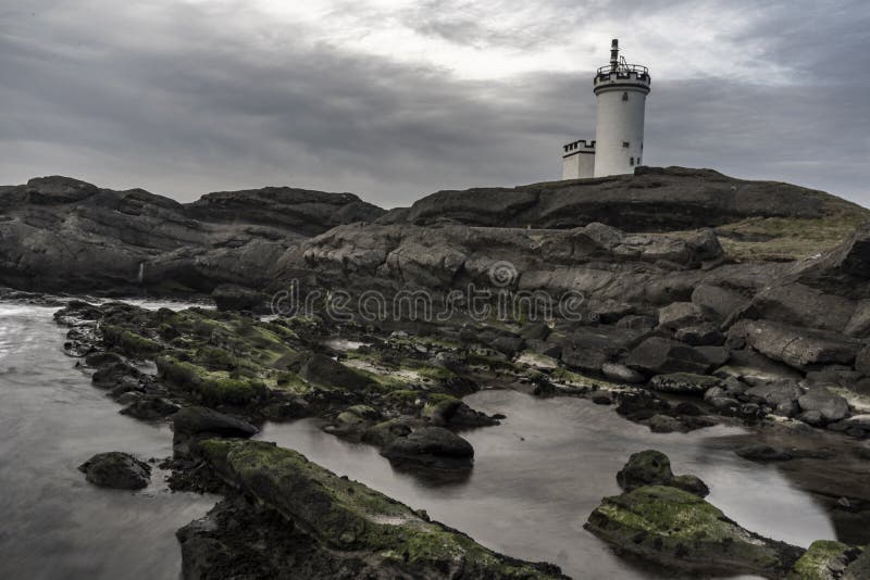 Lighthouse on the Sea Shore Rocks Stock Photo - Image of cloudy ...
