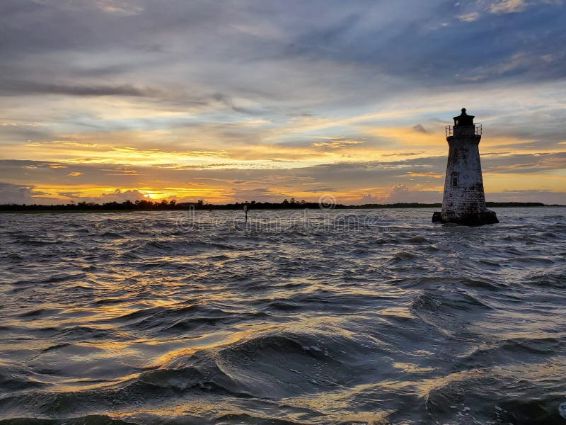 Lighthouse at sea stock image. Image of sunset, ocean - 155522625