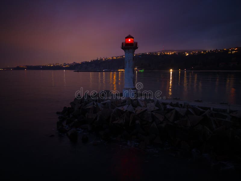 Lighthouse on the Seashore with Red Light at Night Against the ...