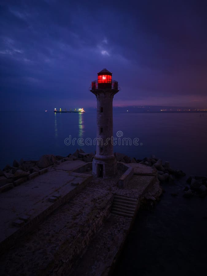 Lighthouse on the Seashore with Red Light at Night Against the ...