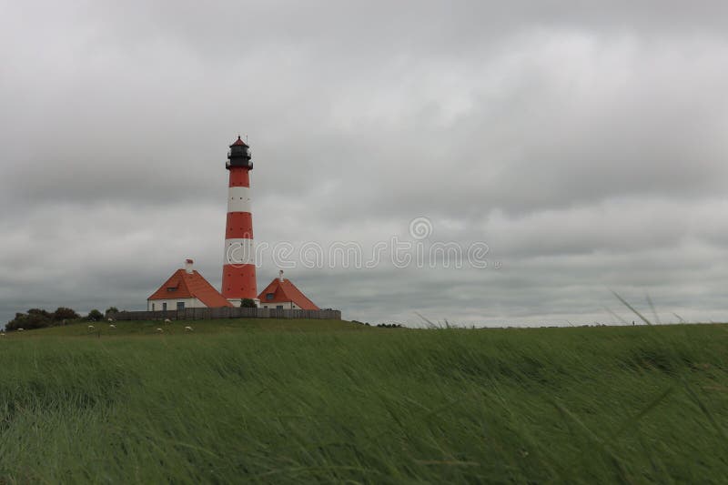 Lighthouse Situated Atop a Lush, Green Hill with a Broad, Grassy Field ...