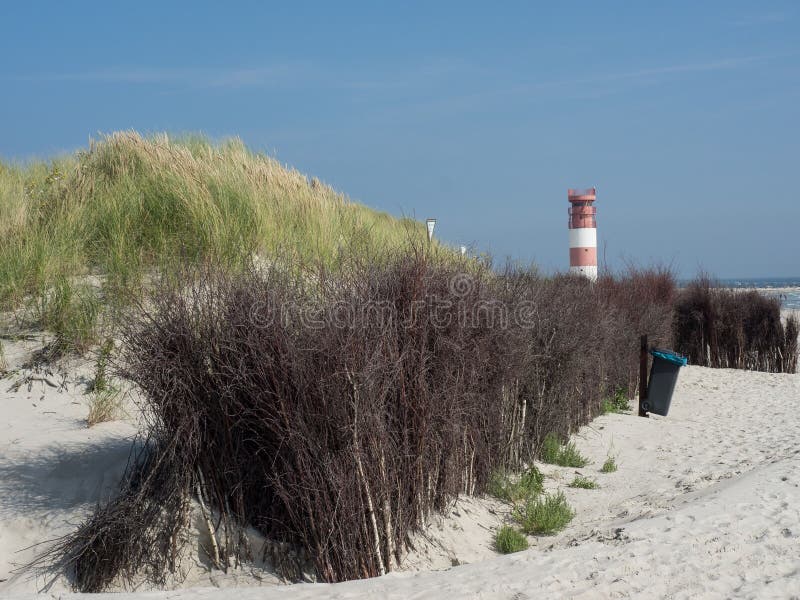 Lighthouse Situated on the Shoreline of a Beach, with Sand and Stones ...