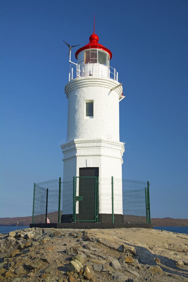 A Lighthouse Stands on a Raised Platform in the Middle of the Sea Stock ...