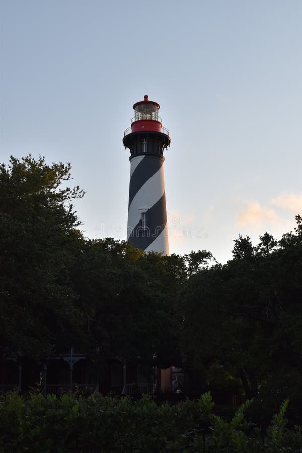 Lighthouse at Sunset Surrounded by Trees Stock Photo - Image of clouds ...