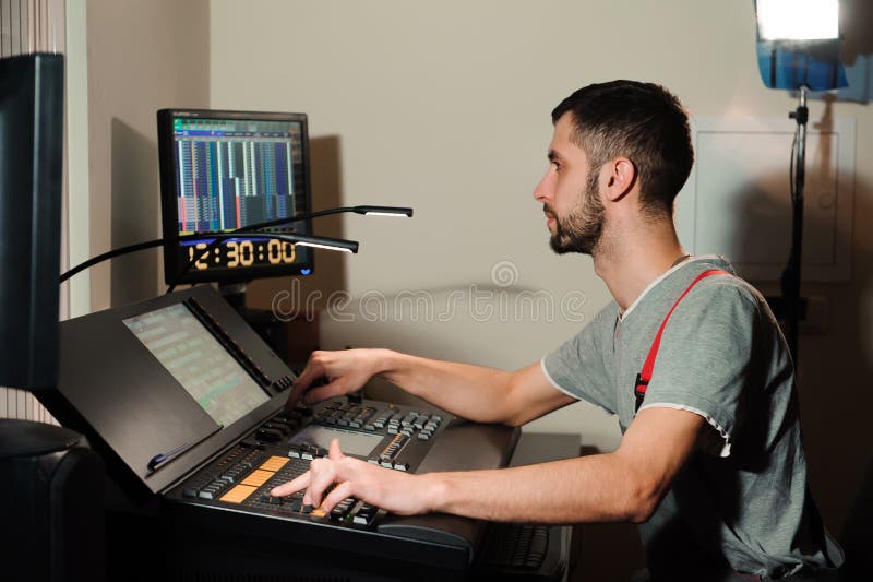 A Lighting Engineer Works with Lights Technicians Control on the ...