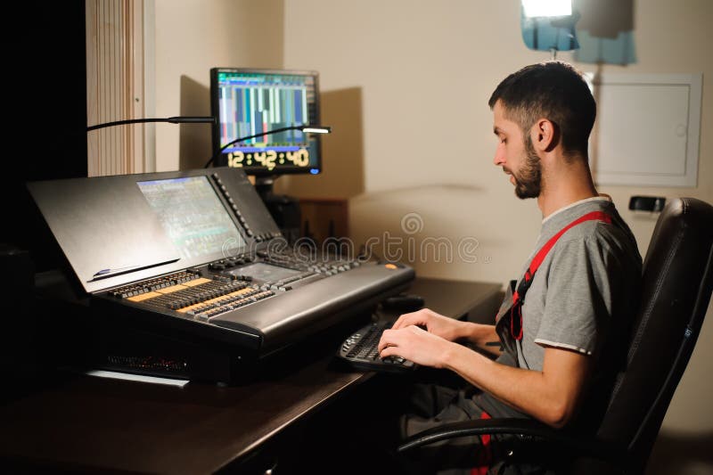 A Lighting Engineer Works with Lights Technicians Control on the ...