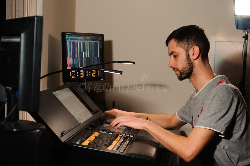 A Lighting Engineer Works with Lights Technicians Control on the ...