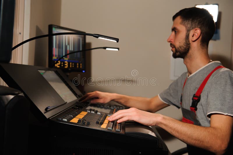 A Lighting Engineer Works with Lights Technicians Control on the ...