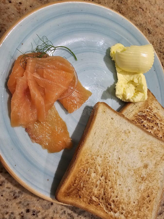Lightly Toasted Bread with Smoked Salmon and Butter on a Blue Plate ...