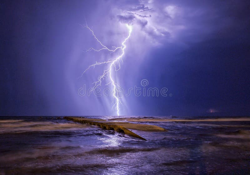 Lightning Over the Ocean with a Pier in the Foreground Stock Photo ...