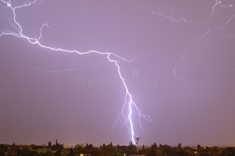 Lightning Streak from a Thunderstorm Cloud at Night in a Rural Setting. There are Multiple ...