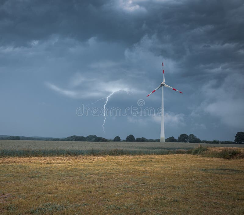 A Lightning Strikes the Ground Next To a Wind Turbine Stock Photo ...
