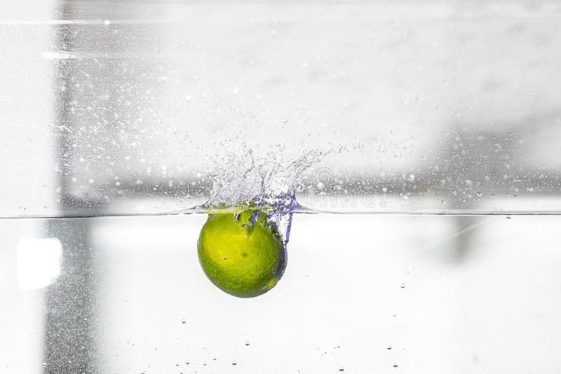 Lime Falls into the Water from Above and Creates Water Splashes Stock ...