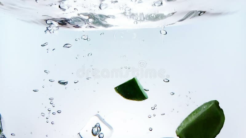 Lime Fruit and Ice Cubes Splash Falling Down into White Cocktail and ...