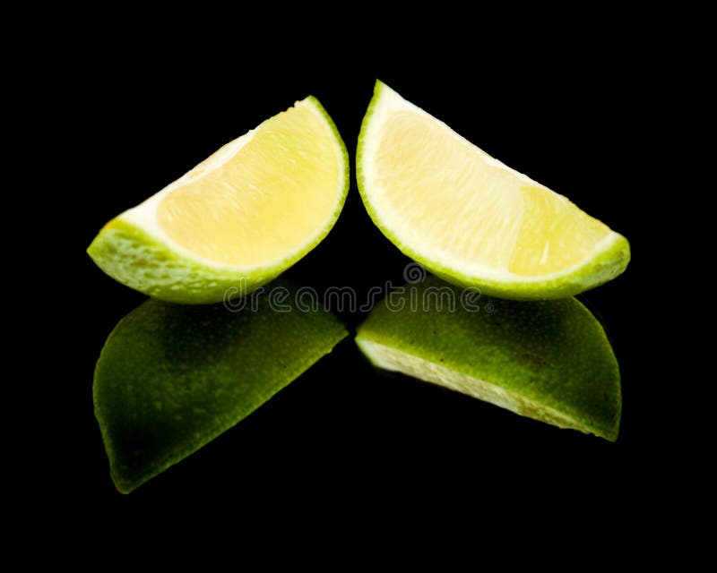 Limes on black mirror stock image. Image of flavour, close - 53625529