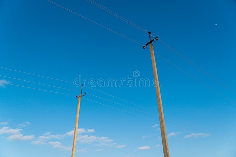 The Line of Electric Poles with Cables of Electric Against Blue Sky ...