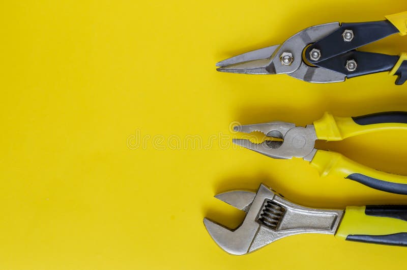 Line of Hand Tools with Black and Yellow Handles on a Yellow Background ...