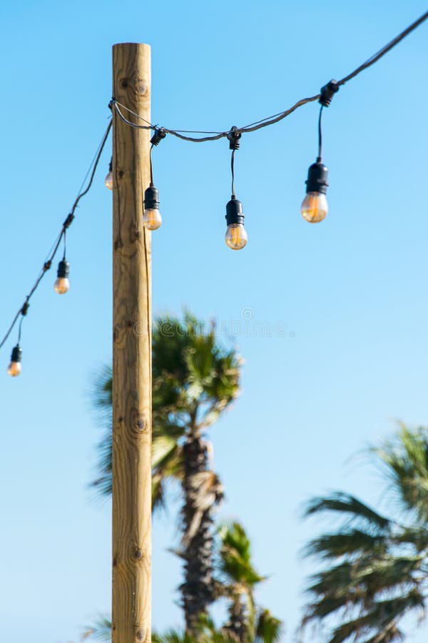 Line of Light Bulbs Lighting the Way To a Terrace on the Beach Stock ...