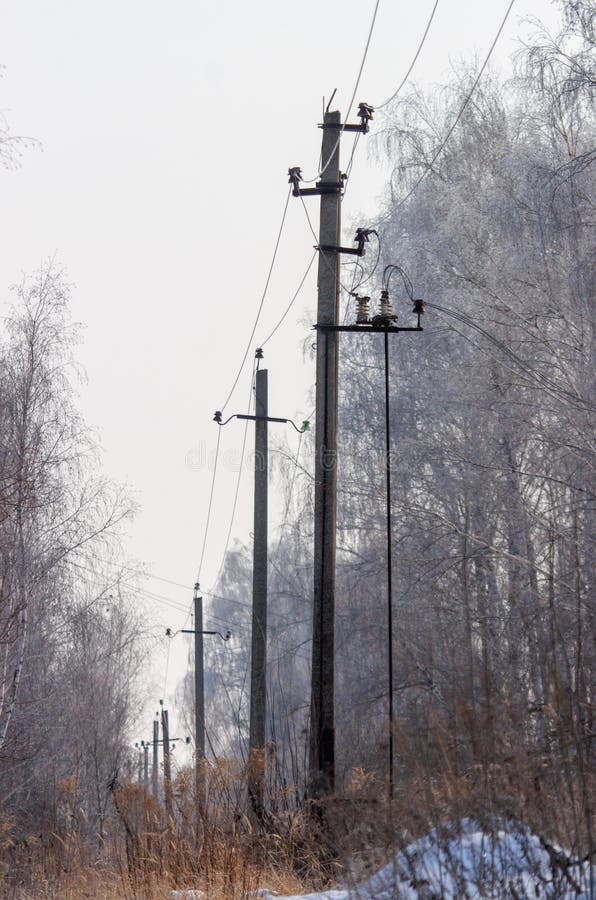 A Line of Power Poles with Wires Hanging Down in the Snow Stock Photo ...