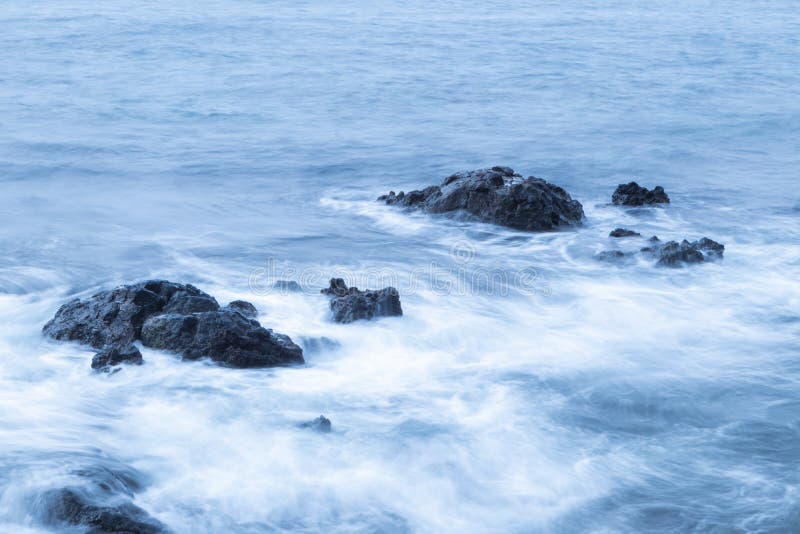 Line of rocks in the sea stock image. Image of wave - 187353243