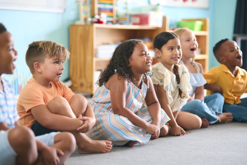 Line of Smiling Primary or Elementary School Students Sitting on Floor ...