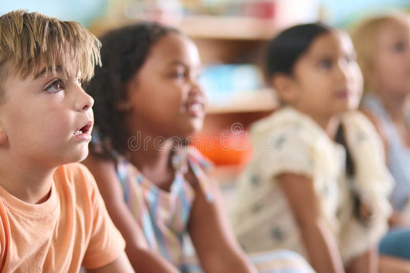 Line of Smiling Primary or Elementary School Students Sitting on Floor ...