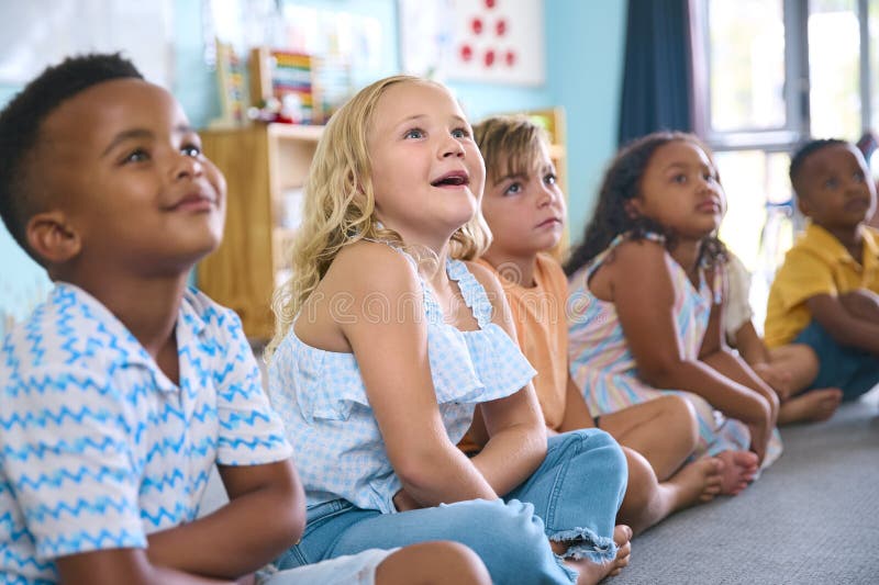 Line of Smiling Primary or Elementary School Students Sitting on Floor ...