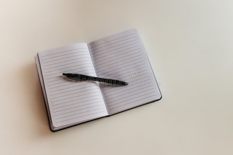 A Lined Open Notepad Book with a Black Pen Placed on a White Isolated ...