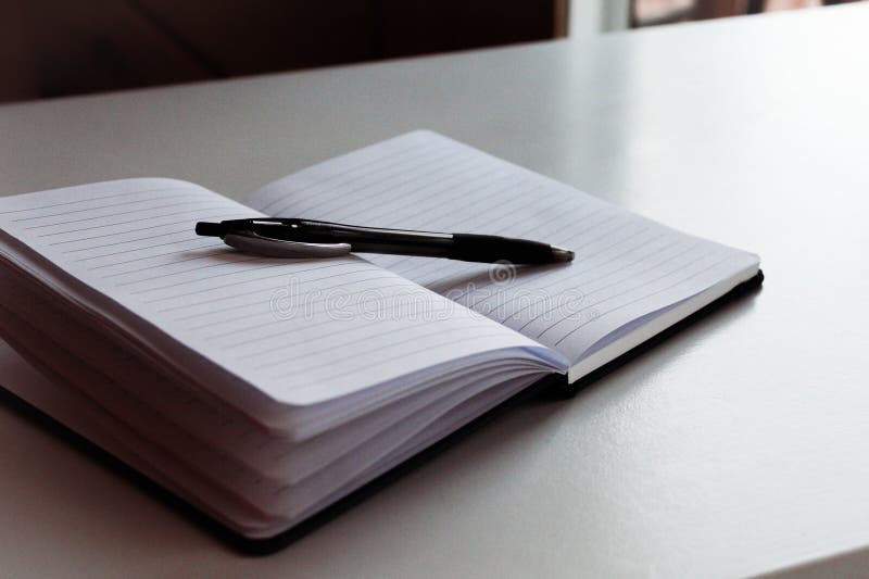 A Lined Open Notepad Book with a Black Pen Placed on a White Isolated ...