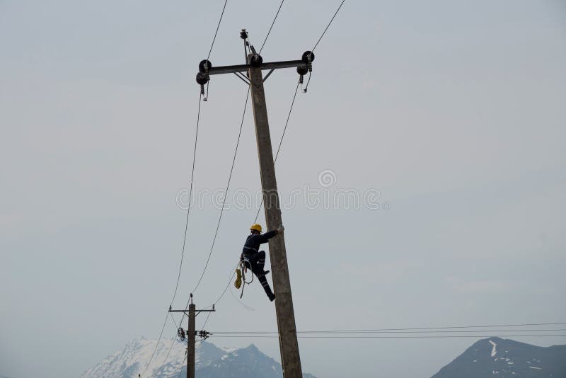 Lineman Climbing Utility Pole with Mountain Backdrop. Stock Image ...
