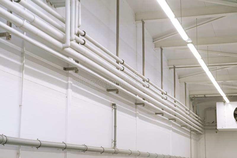 Lines of Plastic Pipelines Fixed Along the Wall in Industrial Building ...