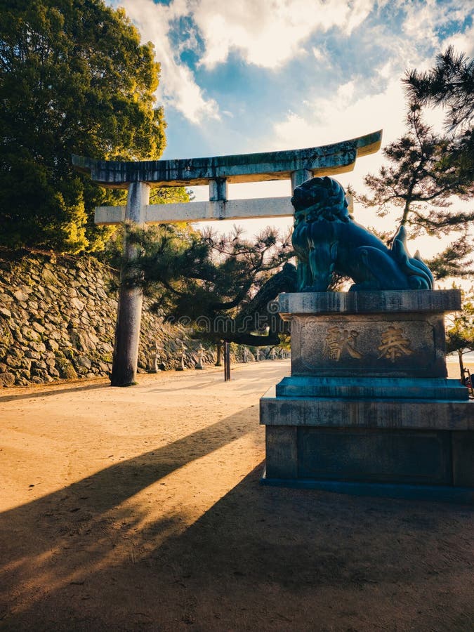 Lion Statue Guarding the Torii Gate Stock Photo - Image of statue ...