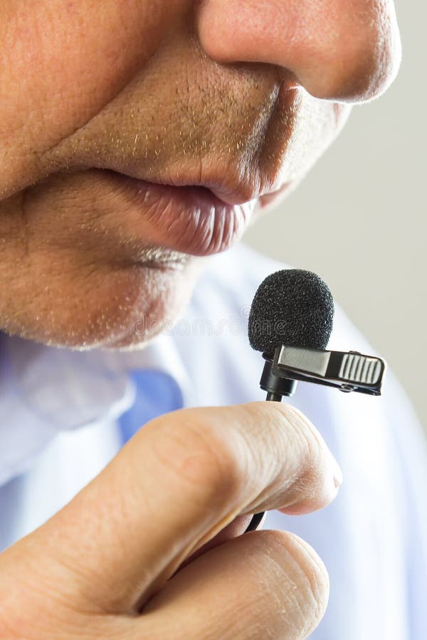 The Man Speaks into a Small Microphone in a Low Voice. Stock Image ...