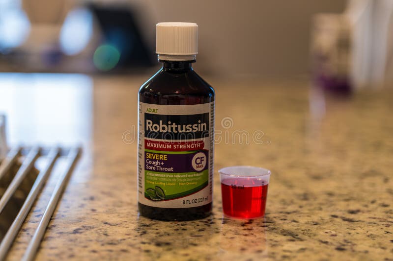 Liquid Cough Medicine with Dosage Cup on Kitchen Counter during ...