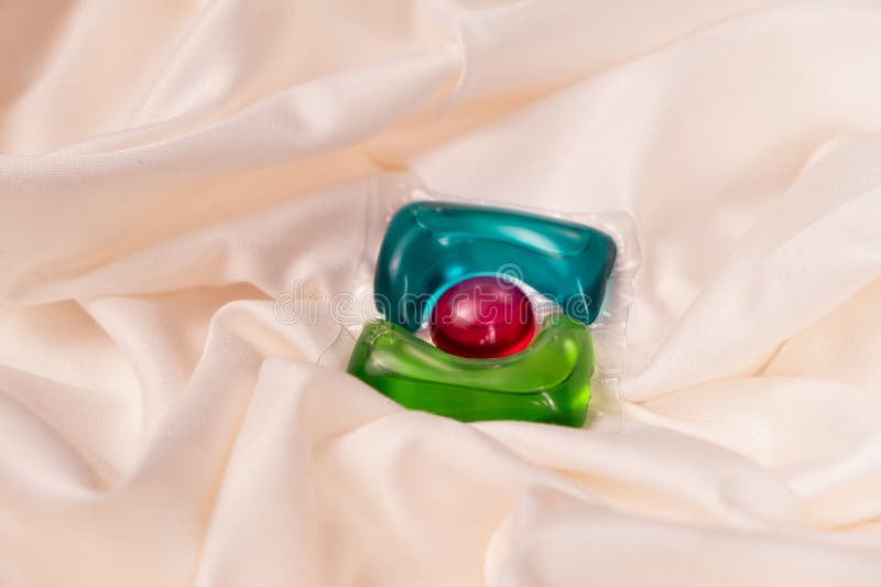 Liquid Detergent Gel in Capsule on Fabric Close-up, Space for Text ...