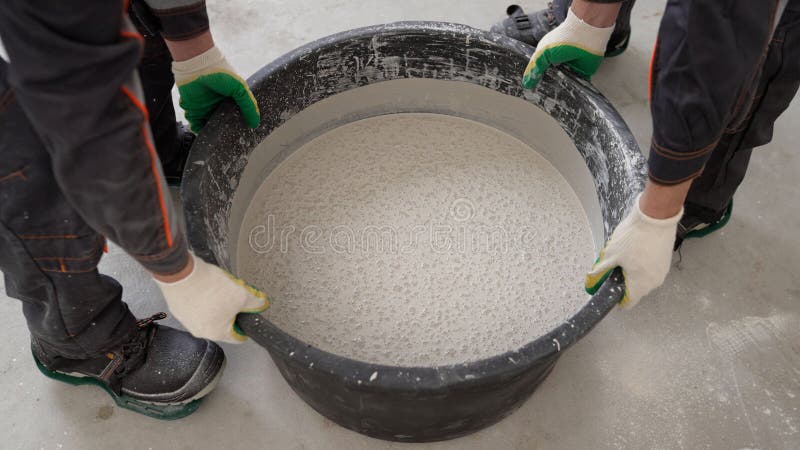 The Liquid Floor is Poured from the Fan. Construction Workers Leveling ...