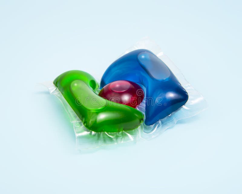 Liquid Powder in Gel Capsule for Washing Multicolor on Blue Background ...