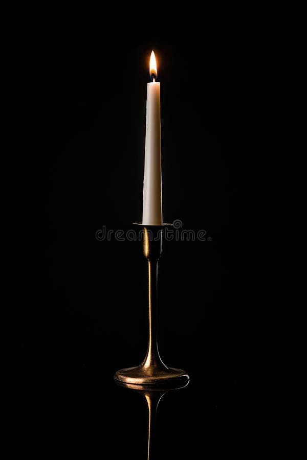 Lit Candle in Brass Holder Against Black Background with Reflection ...