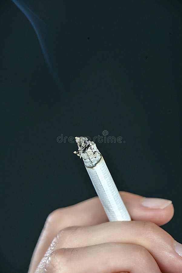 Lit cigarette in hand stock photo. Image of cigarette - 73096726