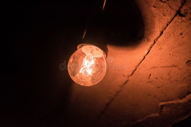 Lit Electric Lightbulb on the Wall in a Dark Setting Stock Image ...