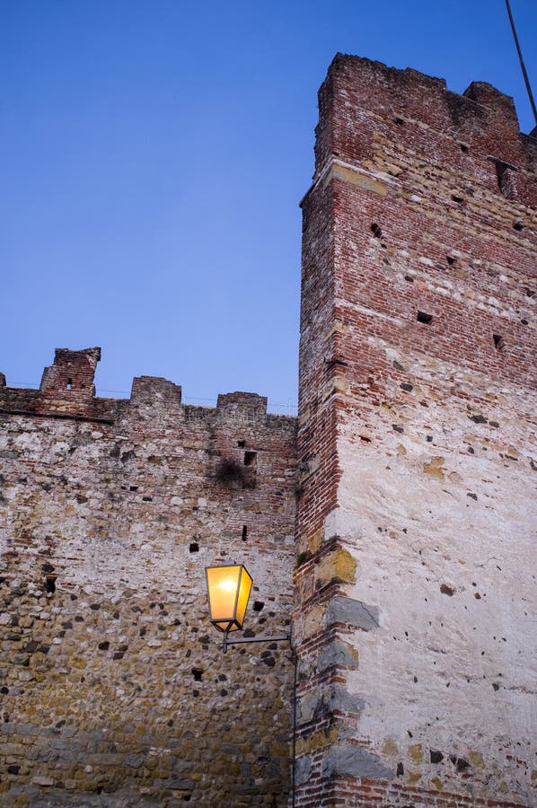 Lit Lamp Post Against a Castle Brick Wall at Night Stock Photo - Image ...