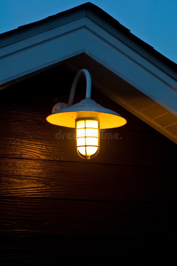 Lit Lamp Post Against a Textured Wooden Wall Stock Photo - Image of ...