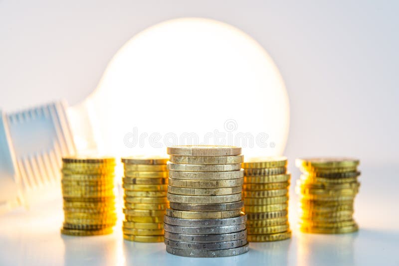 Lit Light Bulb with Coins beside it. Energy Tariffs Increase. Stock ...
