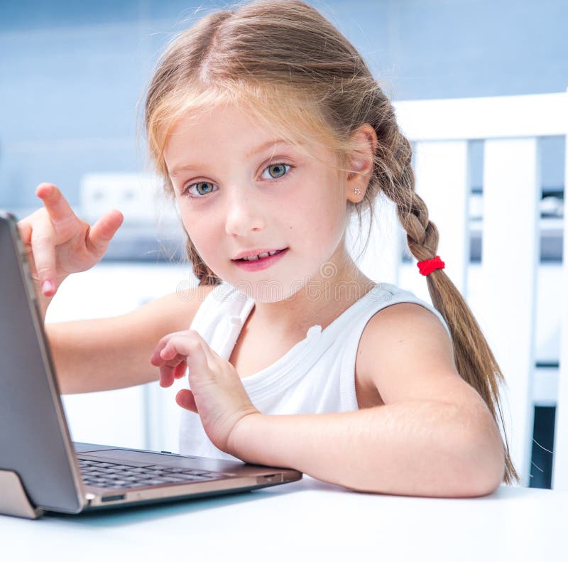 Cute Little Girl Doing Homework on Laptop Fotografering för Bildbyråer ...