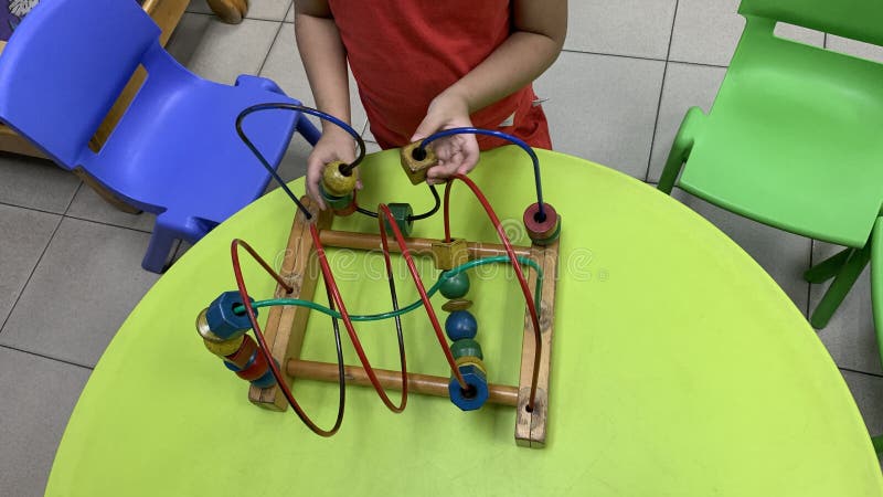 A Little Asian Boy Playing Plastic Rings on the Table. Stock ...