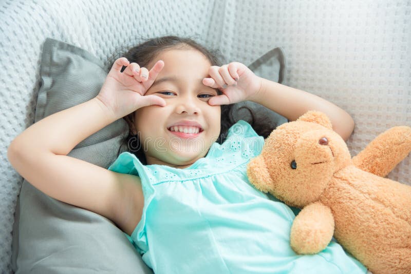 Little Girl Lying on Bed and Smiling at Camera Stock Image - Image of ...