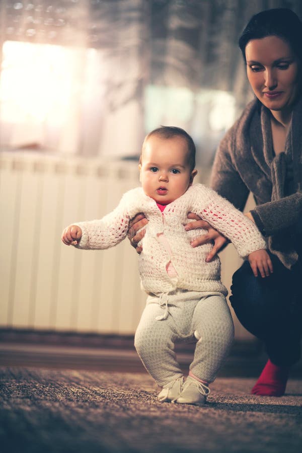 Little Baby Learning To Walk with Mother Help at Home Stock Image ...