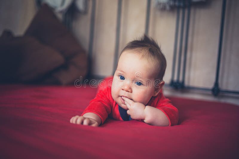 Little Baby in Red on a Bed Stock Image - Image of person, adorable ...