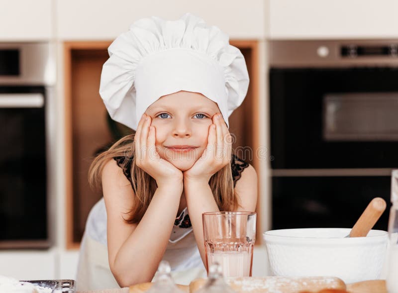 A Little Beautiful Girl in a White Chef Hat in the Kitchen Stock Photo ...