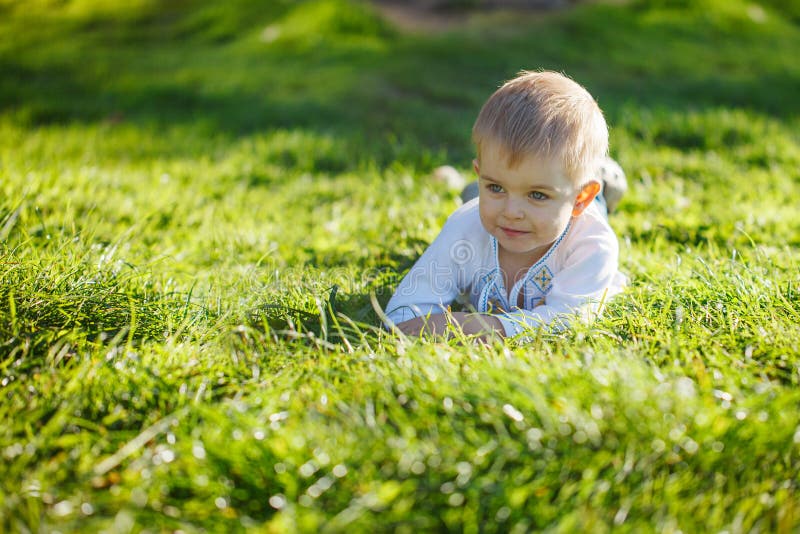 Little Blond Boy Lying on Green Grass in Sunny Summer Day. Stock Photo ...